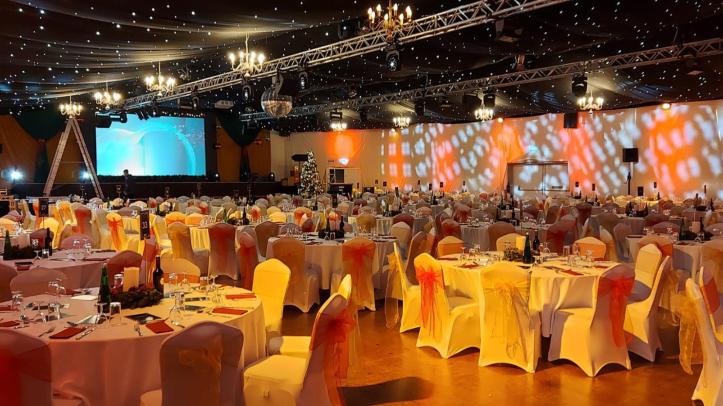 Inside pavilion in the dark with warm lighting and dressed tables